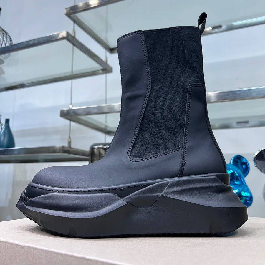 Loading image: Black boot on a white surface with a beige box in the ...